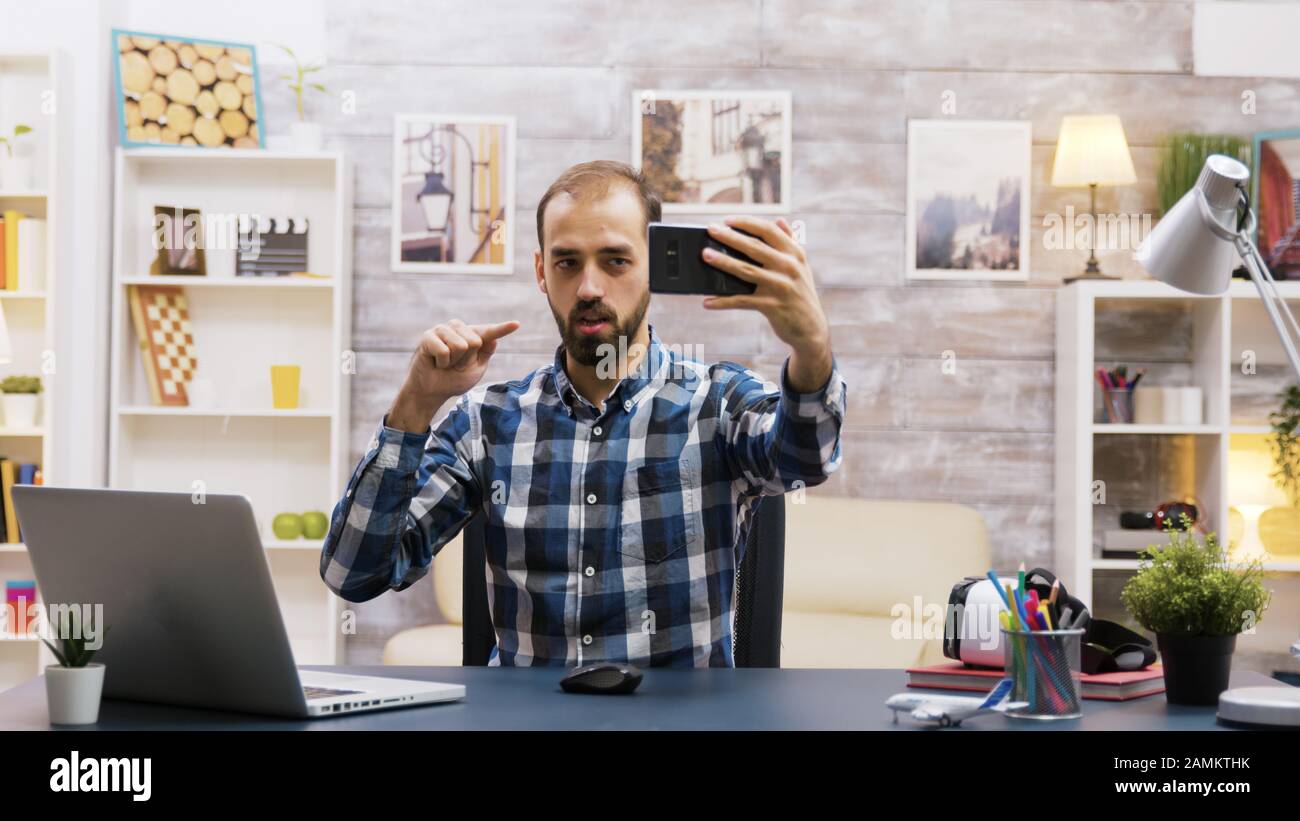 Creative young man using his phone to record a new episode for social ...
