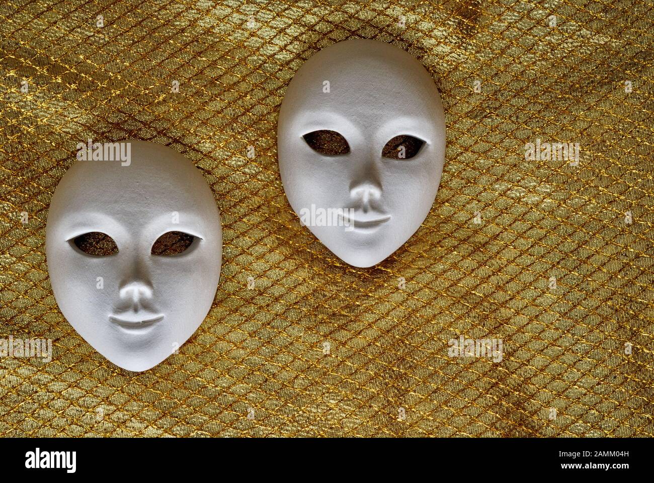 Simple white venetian masks on golden fabric Stock Photo - Alamy