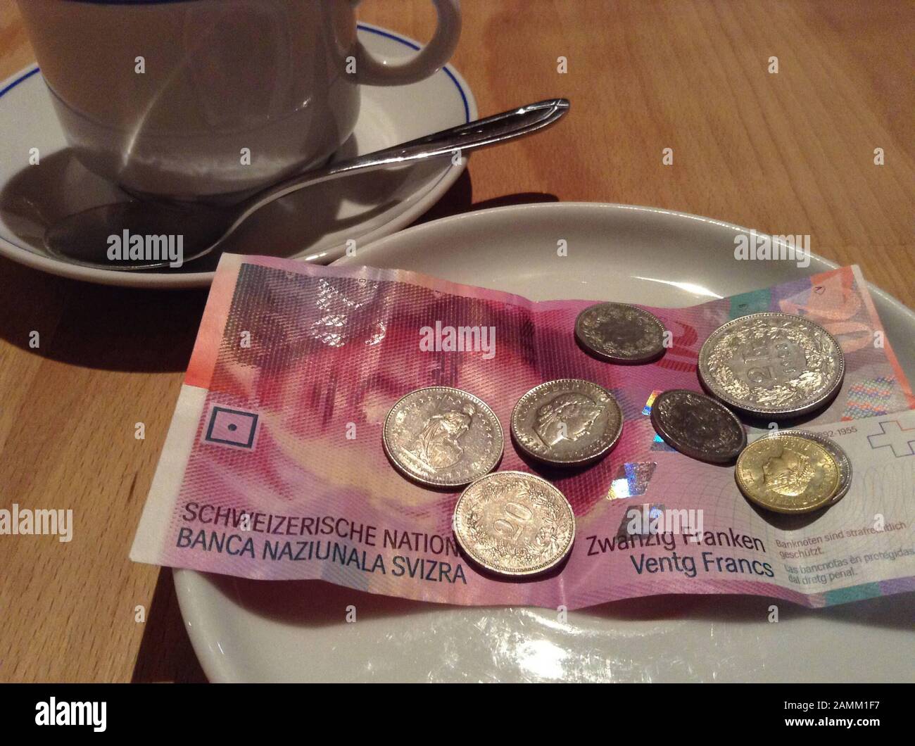 Swiss francs as cash, various coins and 20 franc notes on table in ...