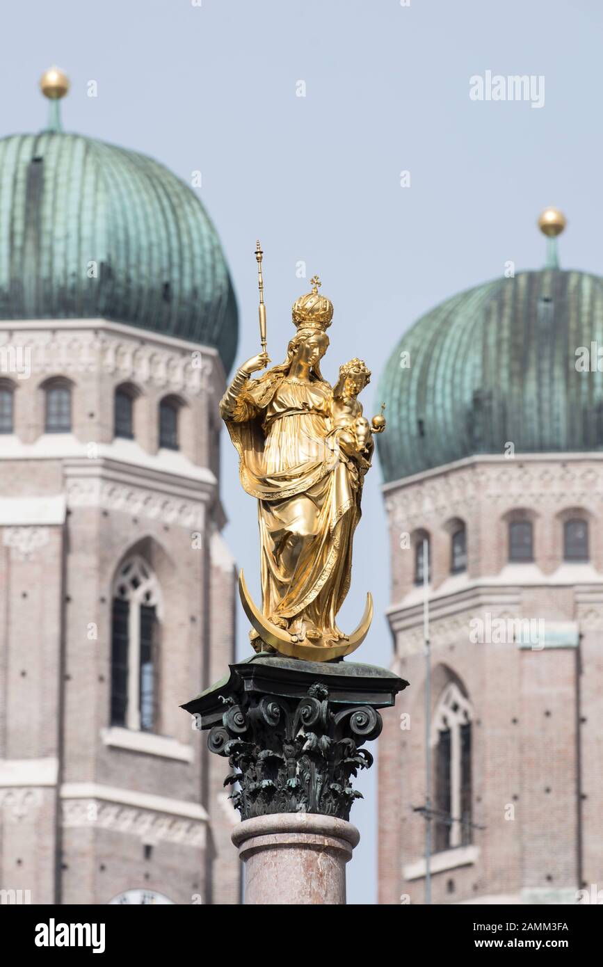 The statue of the Virgin Mary on Munich's Marienplatz with the towers ...