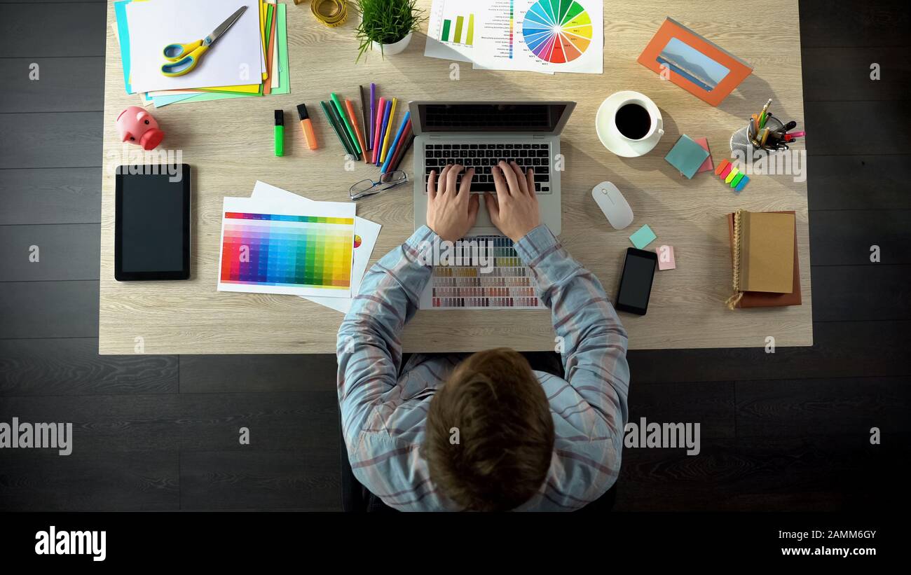 Creative designer typing on laptop, sending art project to client, top ...