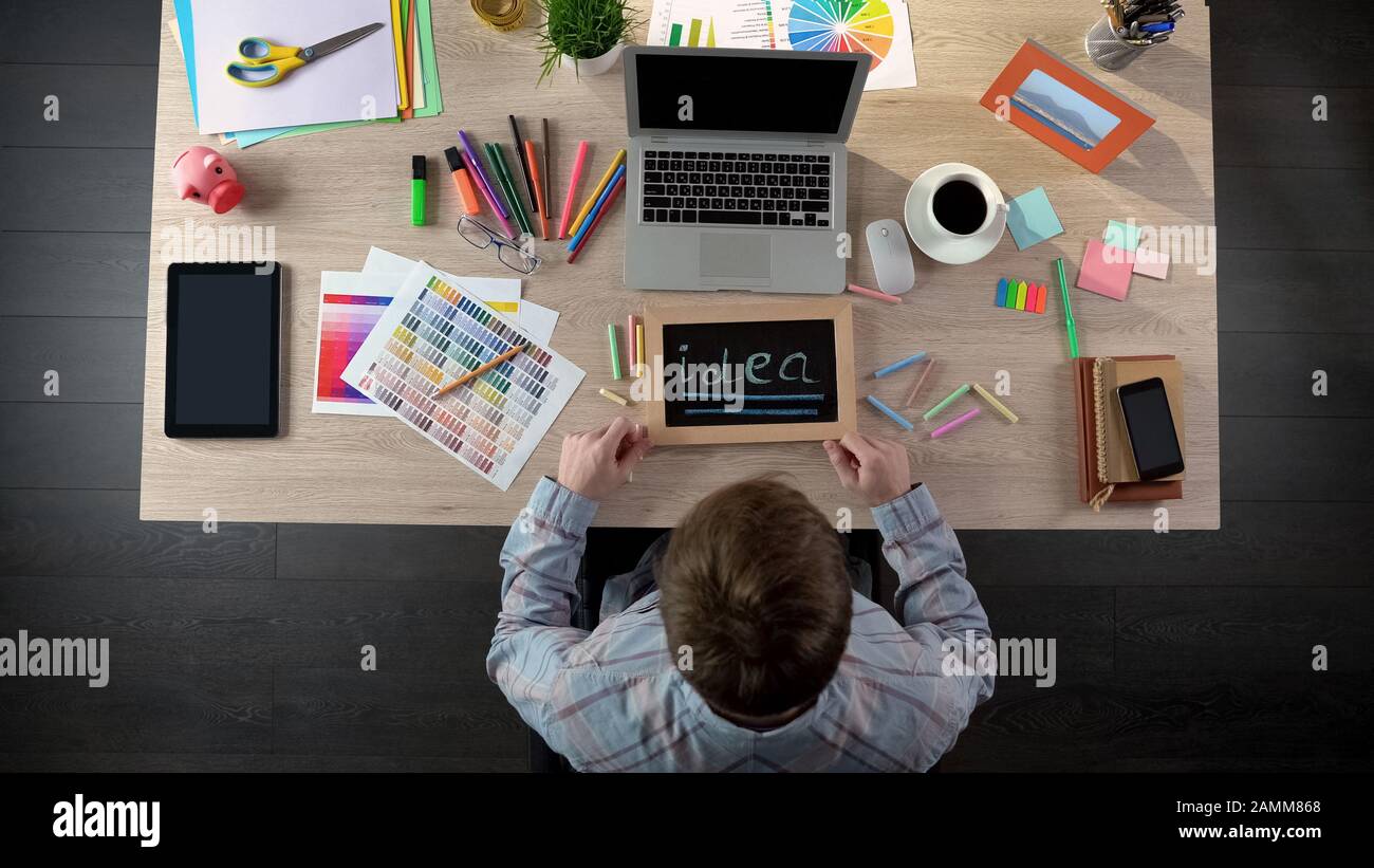 Excited man writing idea on blackboard, full of inspiration to begin ...