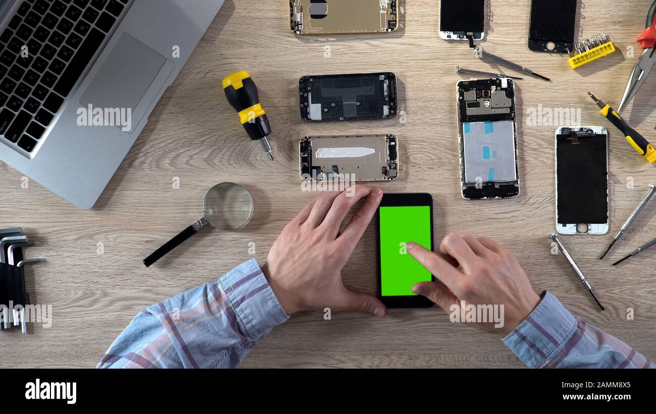 Repairer checking phone functionality after fixing, smartphone with ...