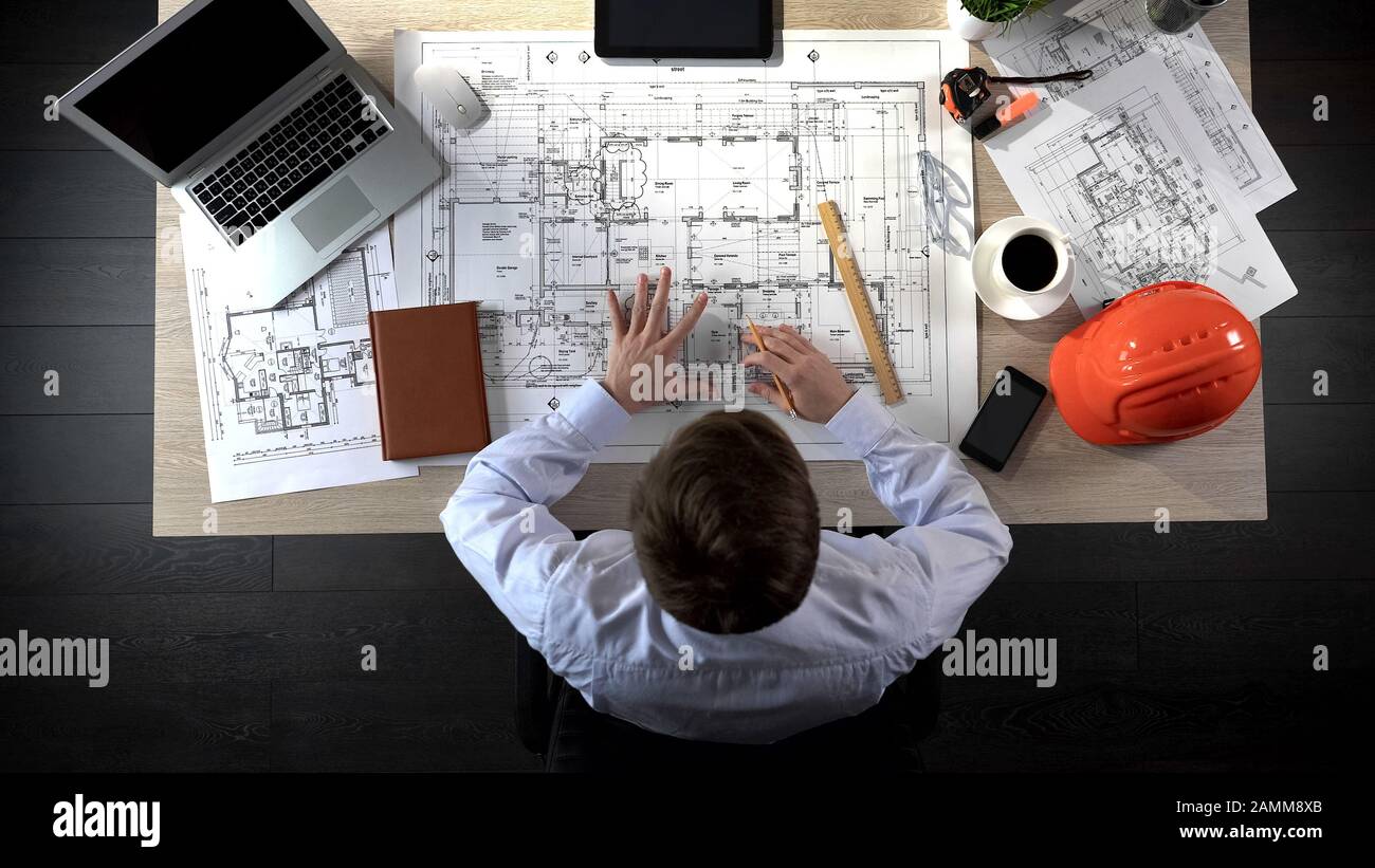 Engineer nervously checking drawings before beginning of building ...