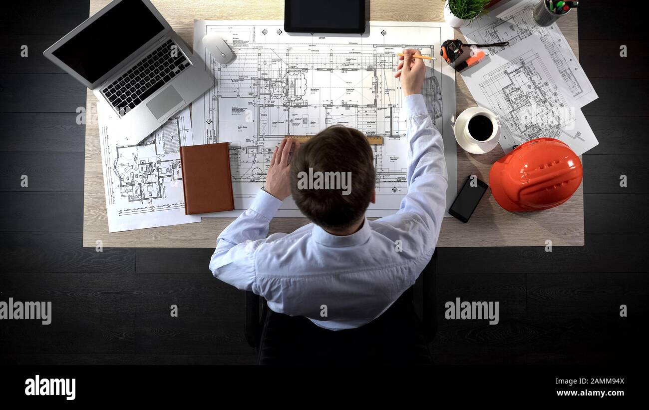 Engineer drawing plan of building, safety engineering, office location ...