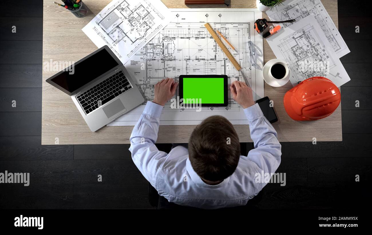 Engineer viewing online layout of building project, using green screen ...