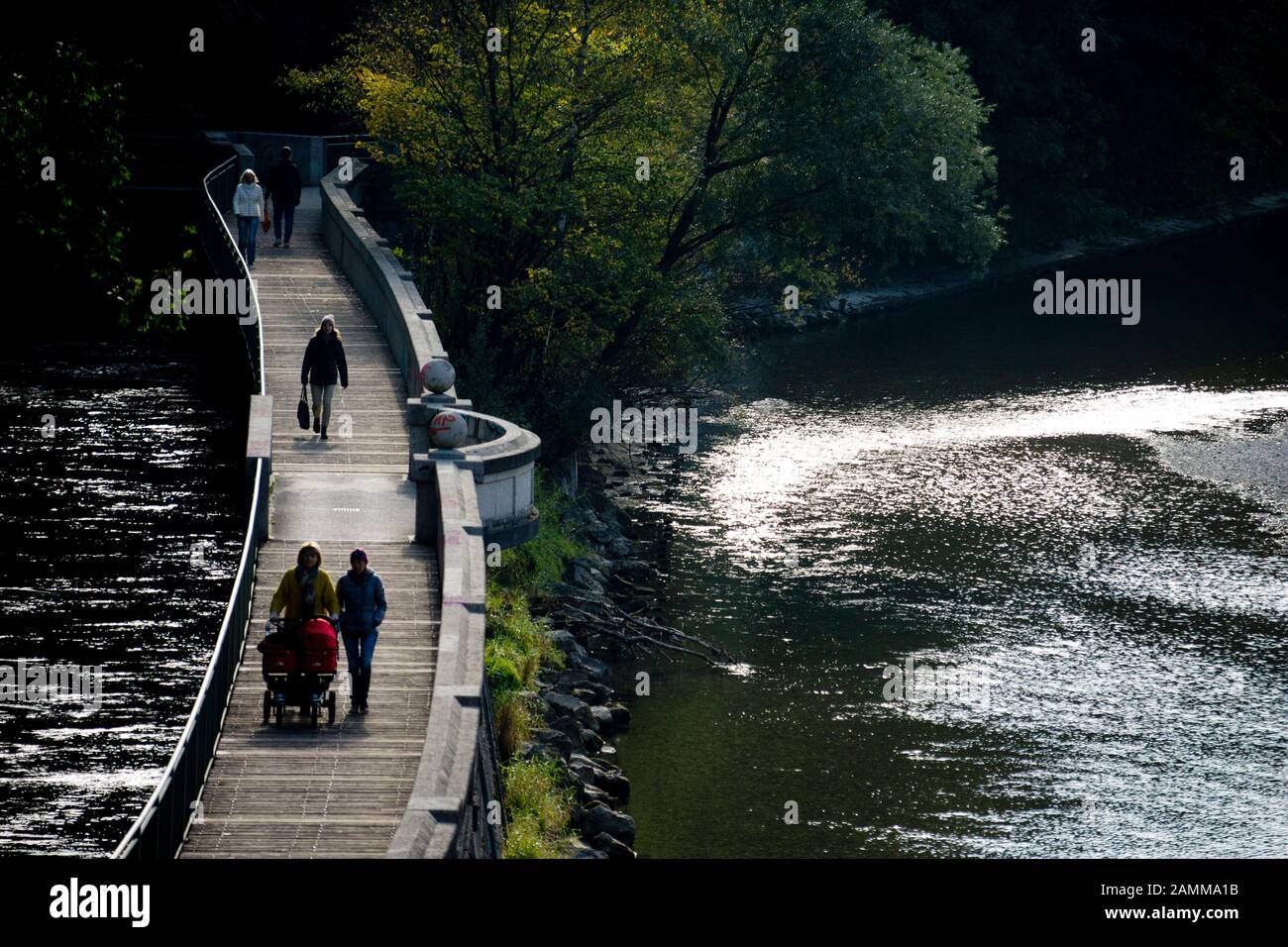 Pedestrians at the Isar river on the bridge below the Bavarian ...