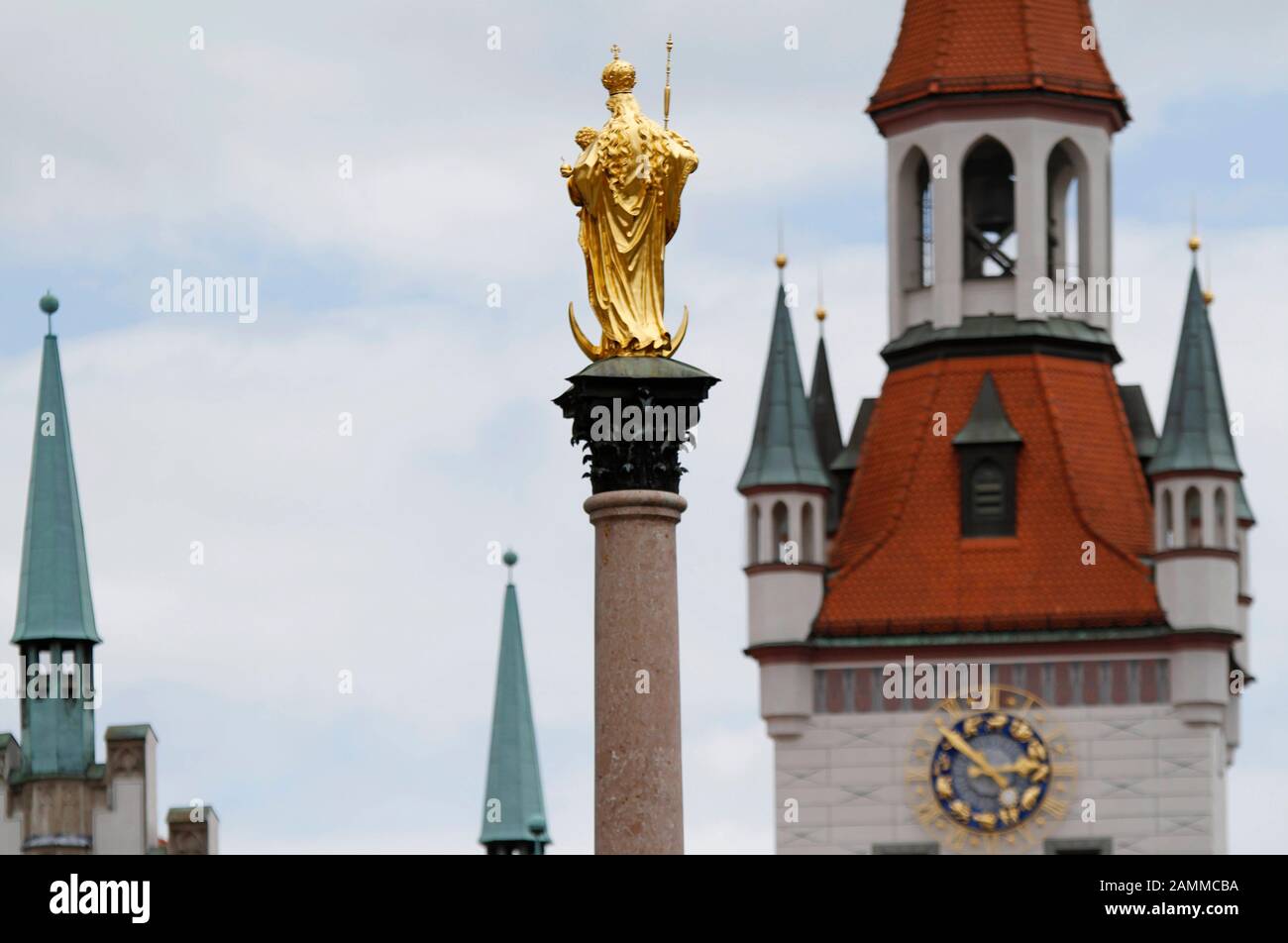 The statue of the Virgin Mary on Munich's Marienplatz with the tower of ...