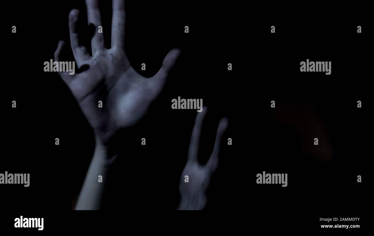 Victim hands stretching out in darkness, begging for help, scary ...