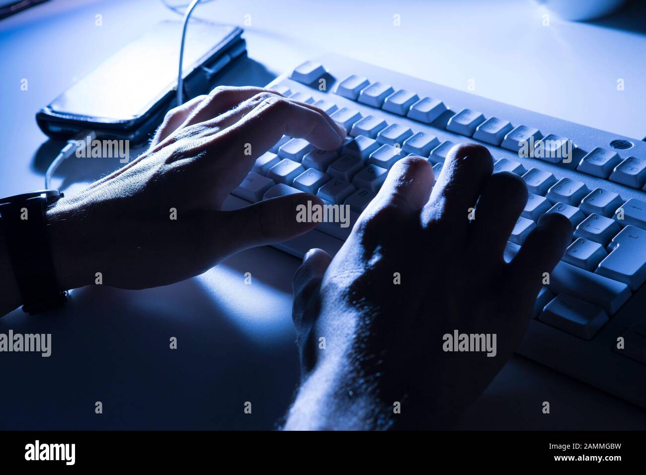 Symbol image for cybercrime: hands on the keyboard of a computer ...