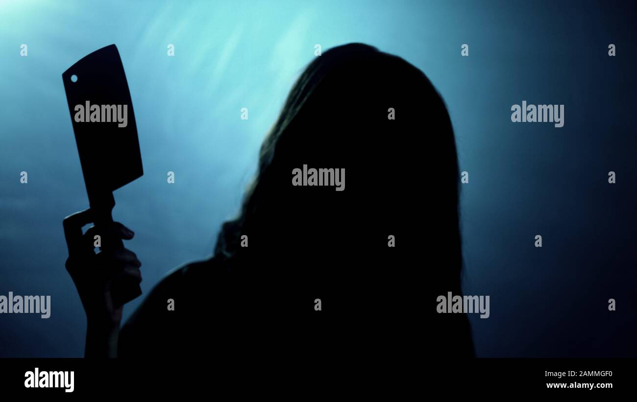 Scary silhouette of female murderer with butcher knife looking into ...