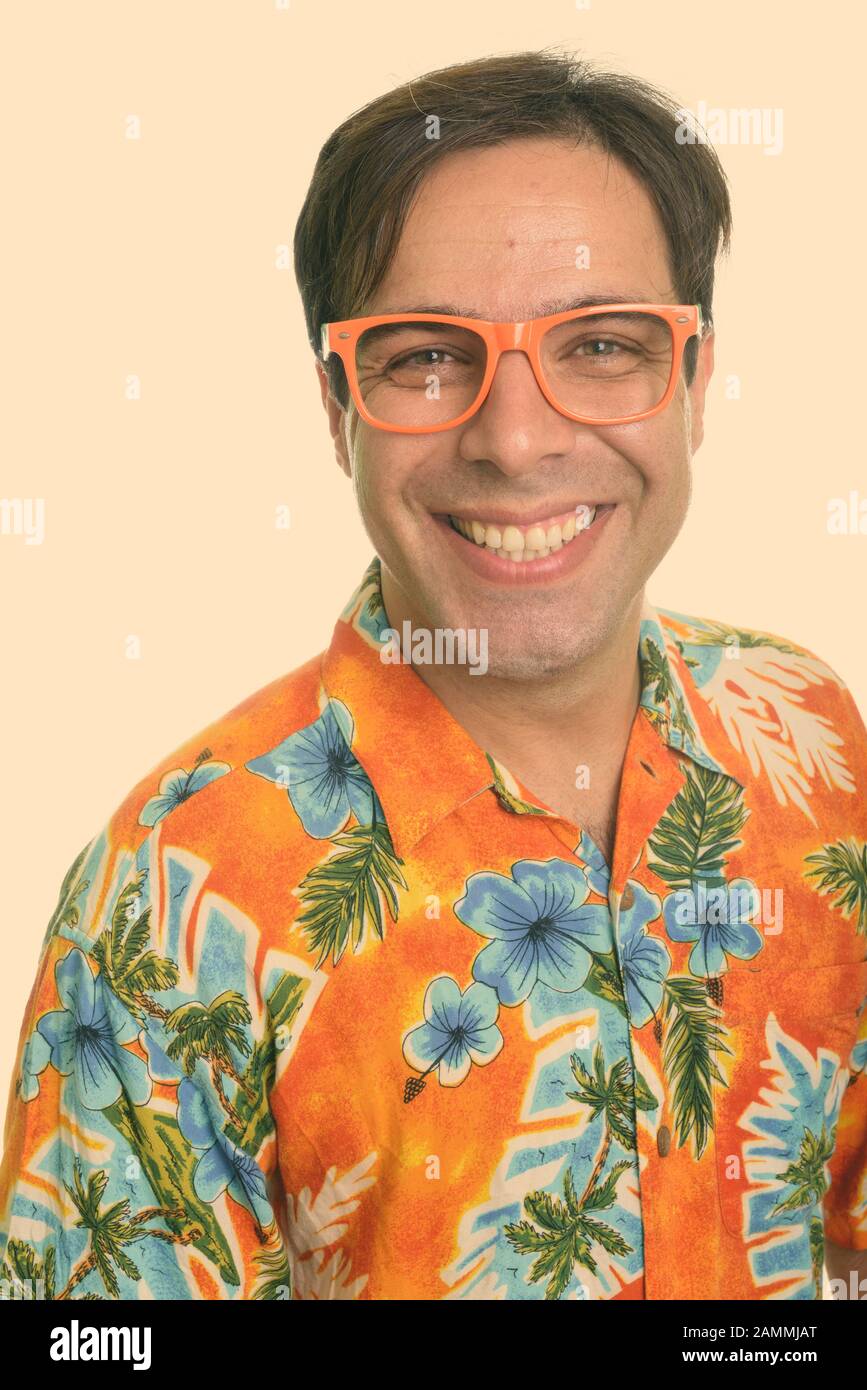 Face of young happy Persian tourist man smiling while wearing orange ...