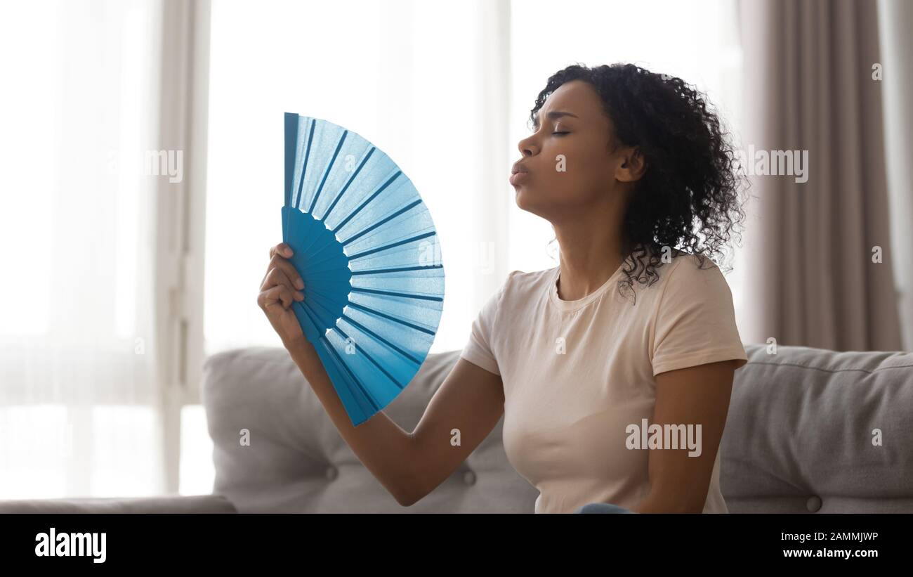 African woman cools herself with fan in hot weather Stock Photo - Alamy