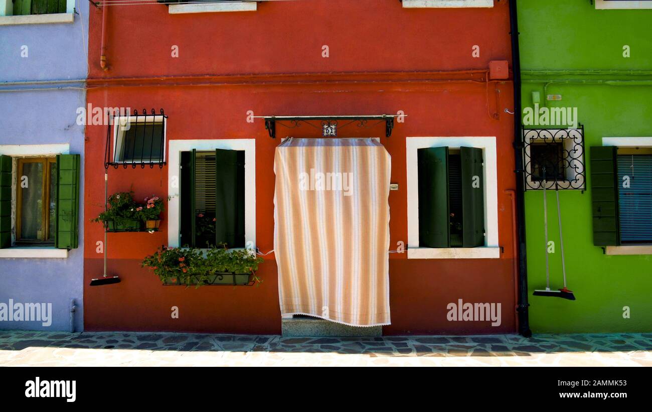 Cozy house painted in red color, famous colorful architecture on Burano ...