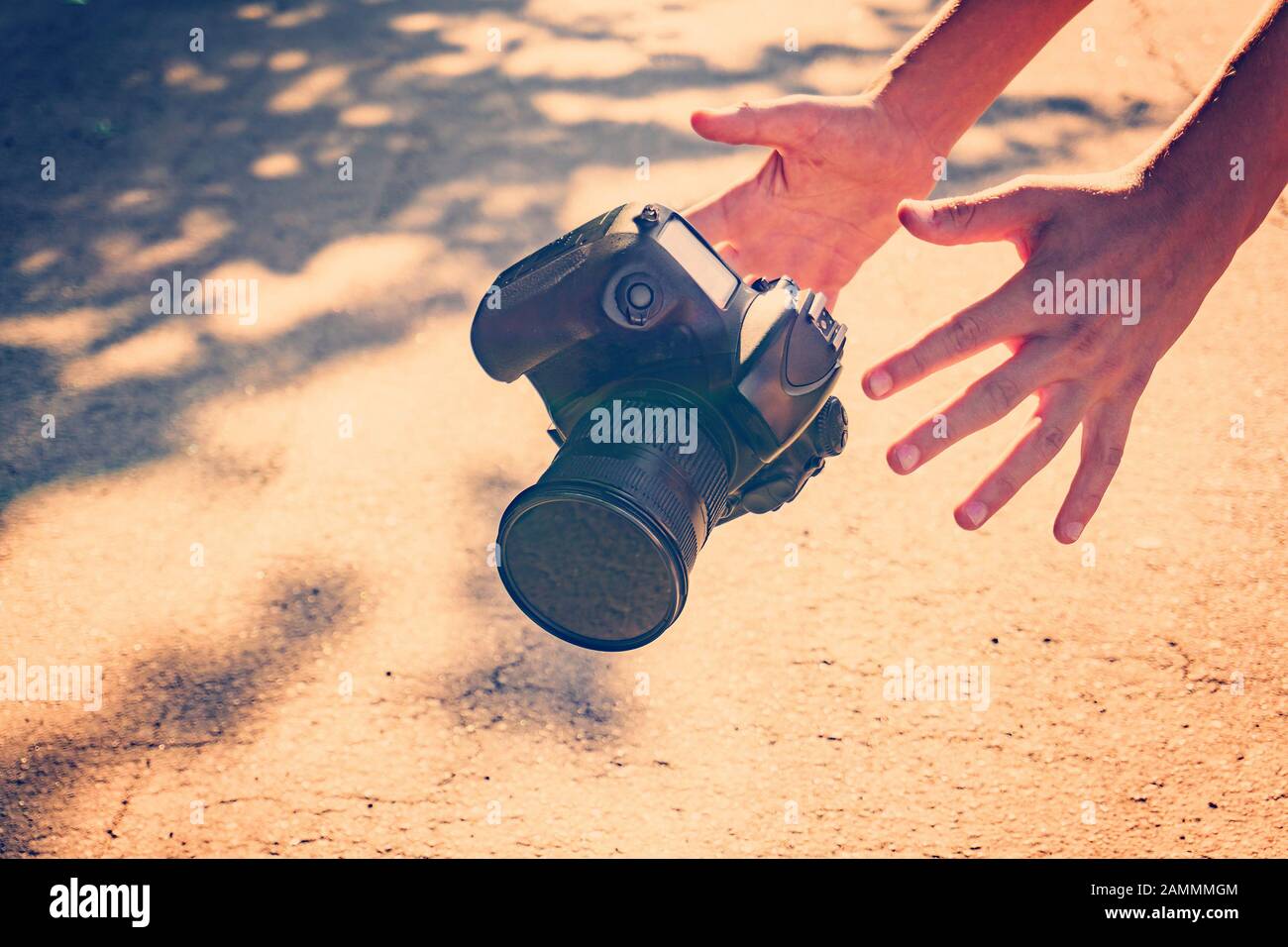 The photographer dropped the camera and catches it with his hands, the ...