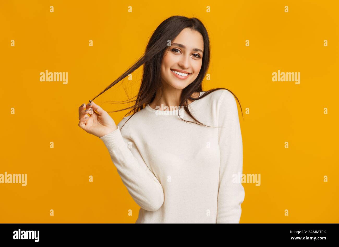 Happy brunette girl flirting and touching her long beautiful hair Stock ...