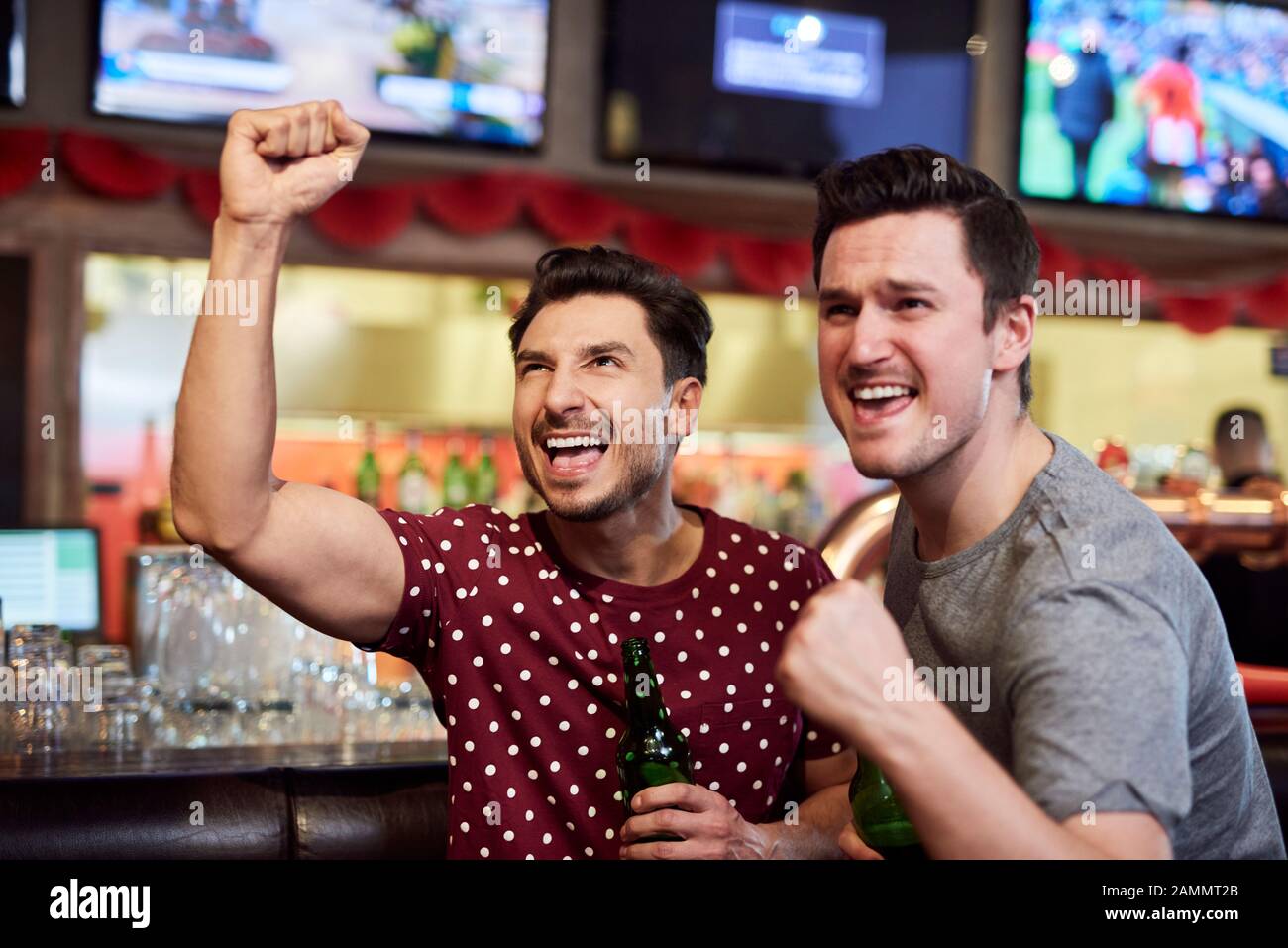 Two friends watching tv with football hi-res stock photography and ...