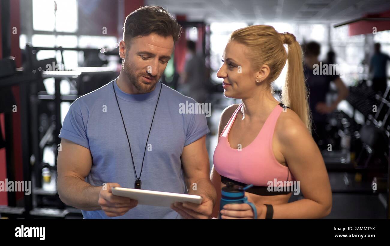 Smiling sport woman looking with interest her personal coach, flirting ...