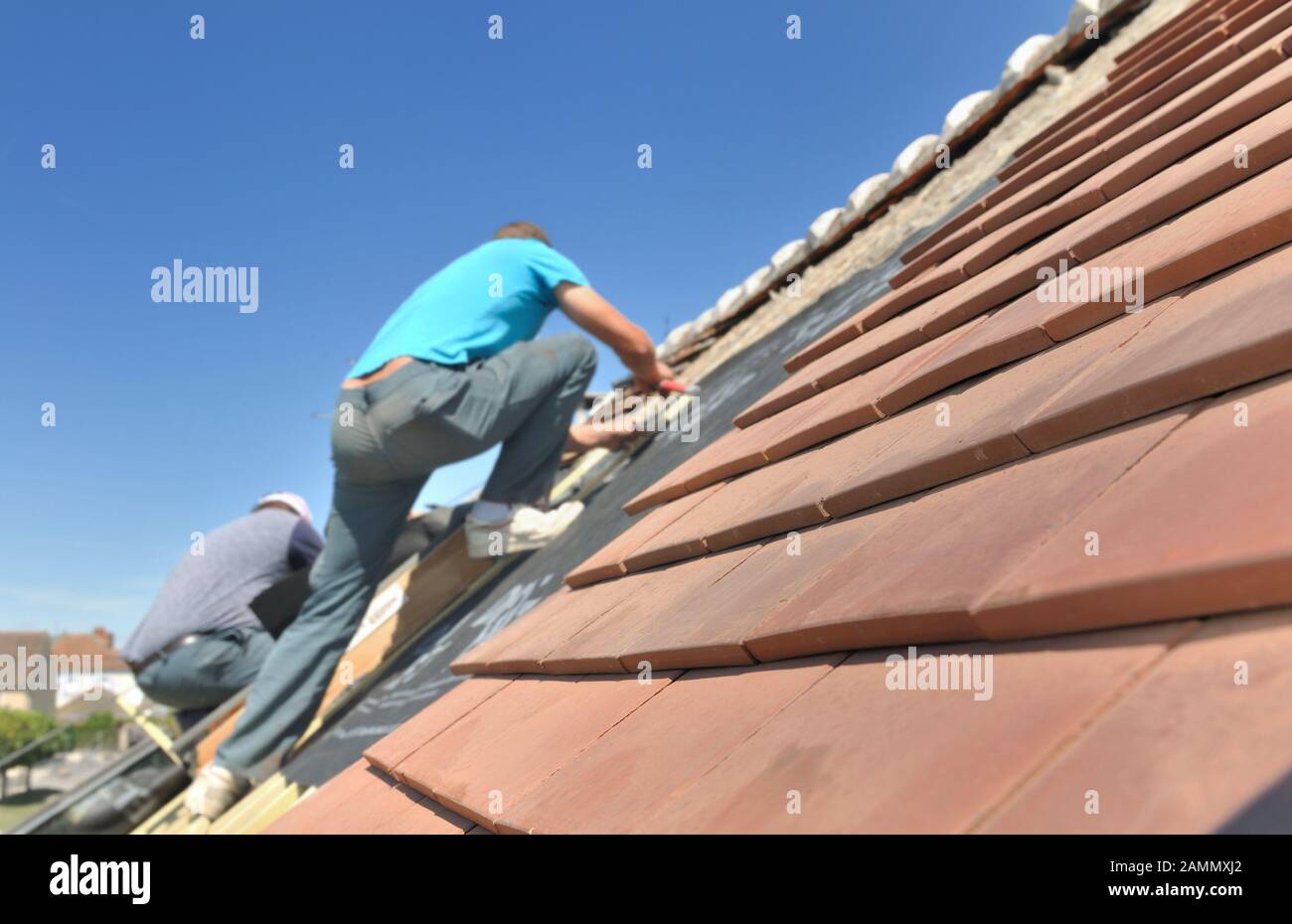 roofers on a roof working to renovation of a house Stock Photo - Alamy