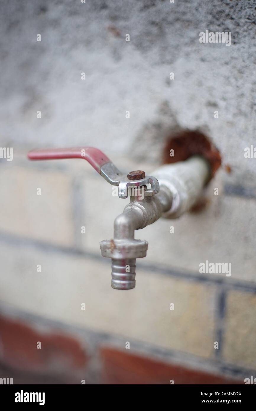 iron water tap protruding from a building wall Stock Photo - Alamy
