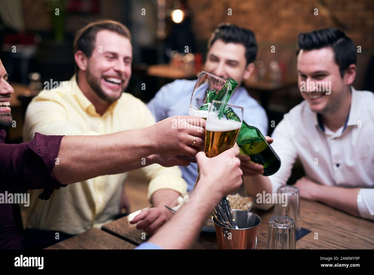 Group of men making a cheers at the bar Stock Photo - Alamy