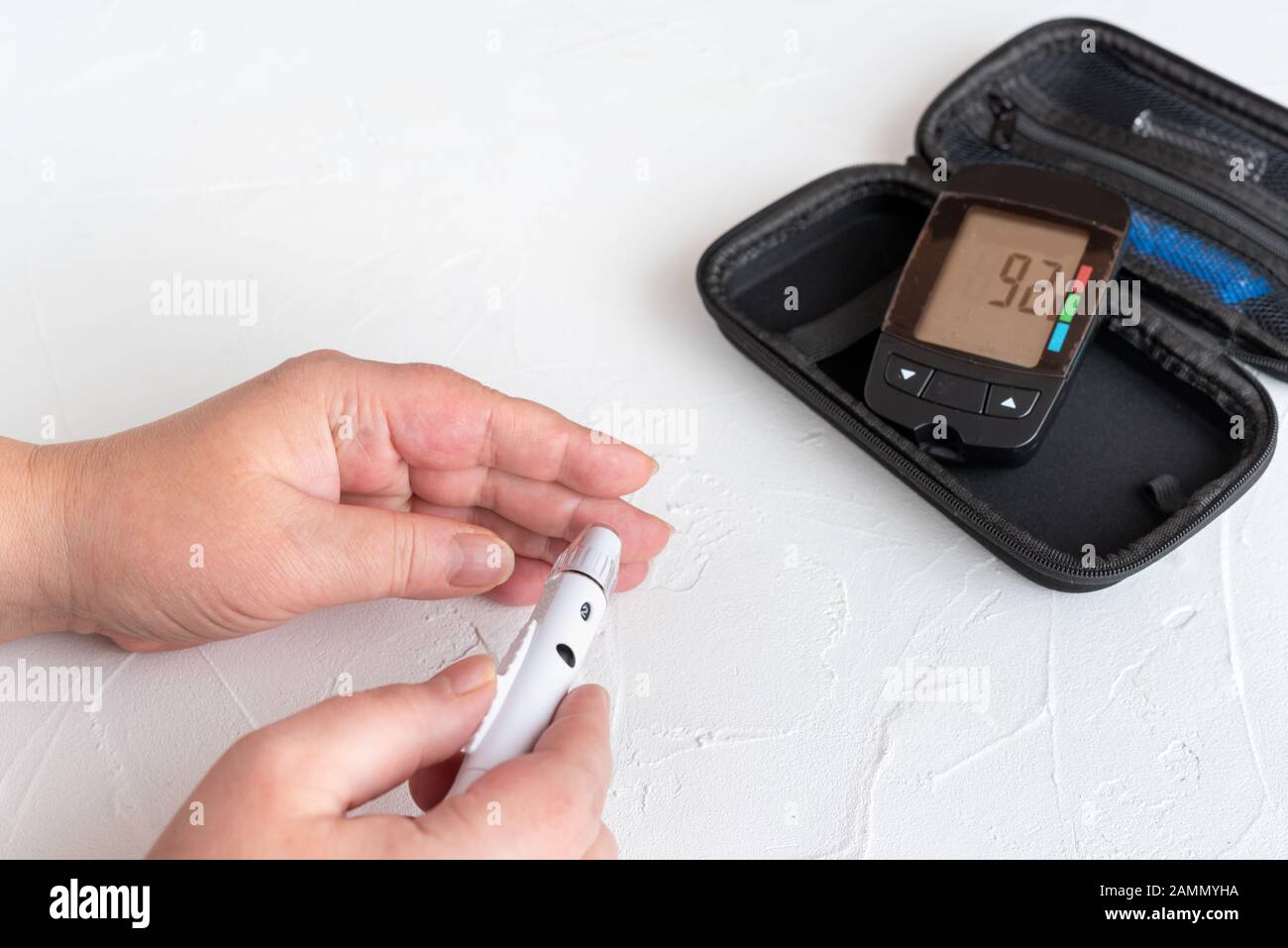Patient hands measuring glucose level blood test with glucometer Stock ...
