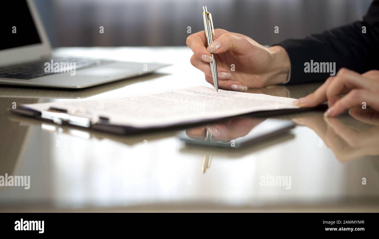 Woman in suit reading terms and conditions of agreement, signing ...