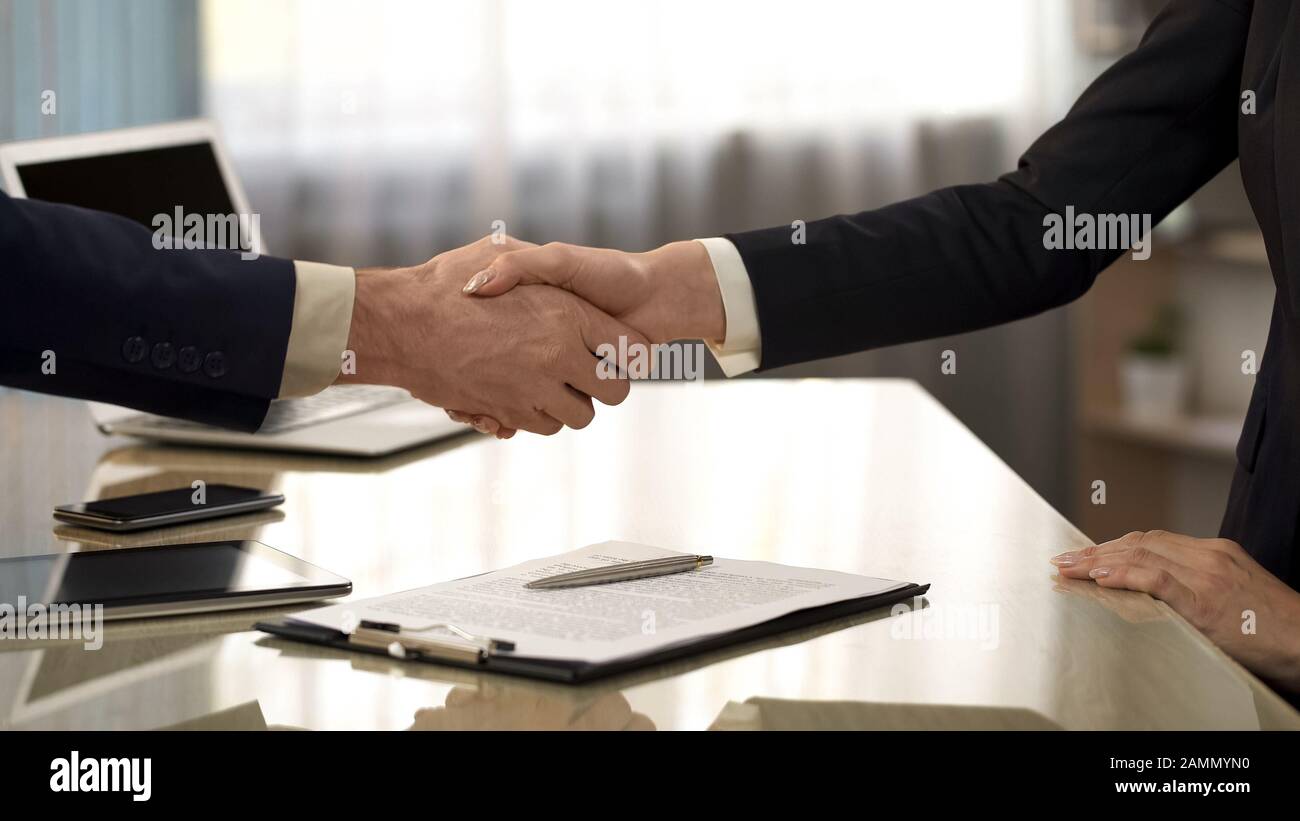 Business partners shaking hands after contract signing, companies ...