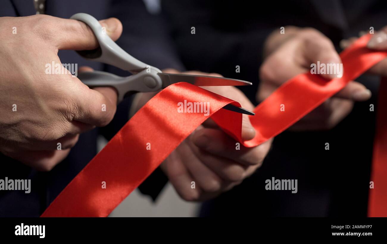 Business people hands cutting red ribbon close-up, new project, opening ...