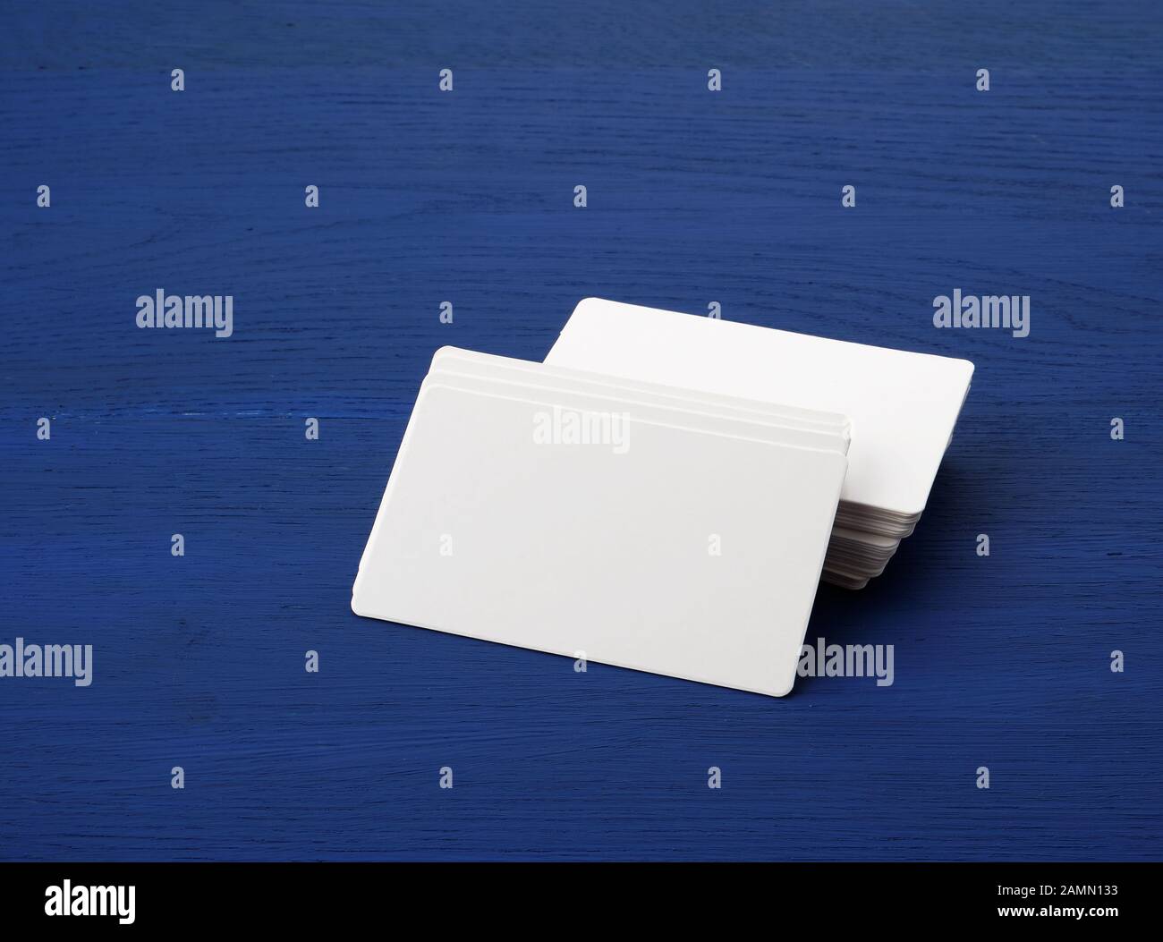 stack of white blank paper rectangular business cards on blue wooden ...