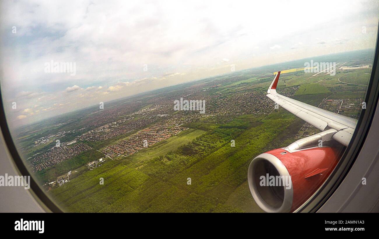 POV of flight passenger looking through window at ground, sky and ...