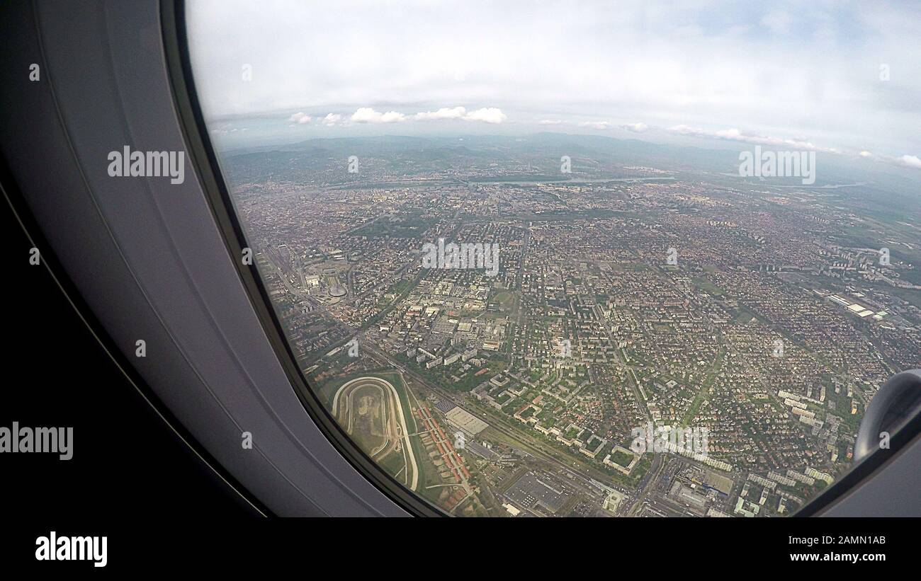 Large city seen through window of plane flying high in sky, air travel ...
