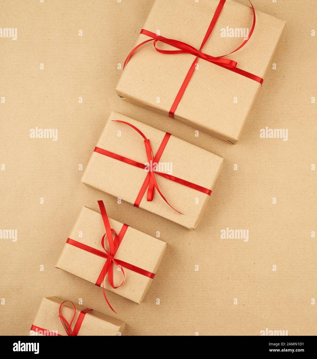 gift wrapped in brown kraft paper and tied with a thin silk ribbon on a ...