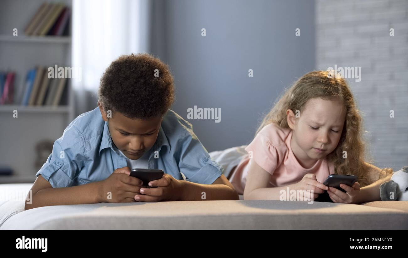 Little children addicted to mobile phones playing games with ...
