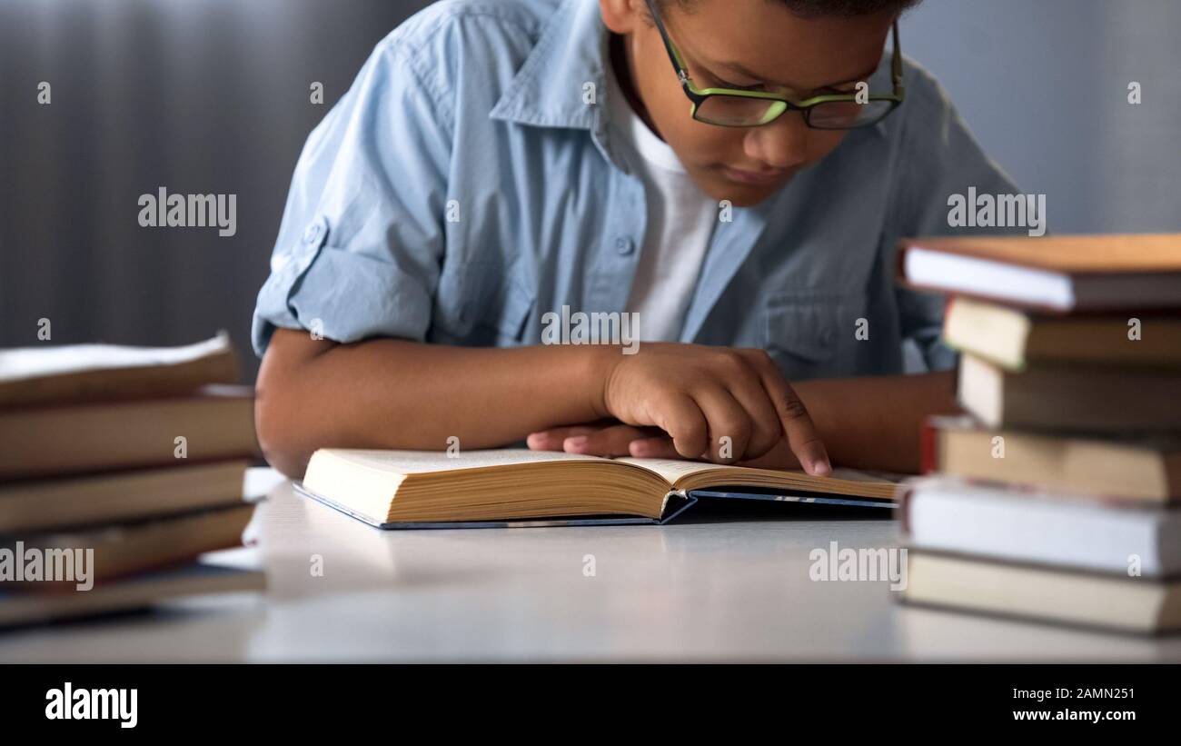Smart Afro-American boy reading books, bookworm kid, little nerd ...