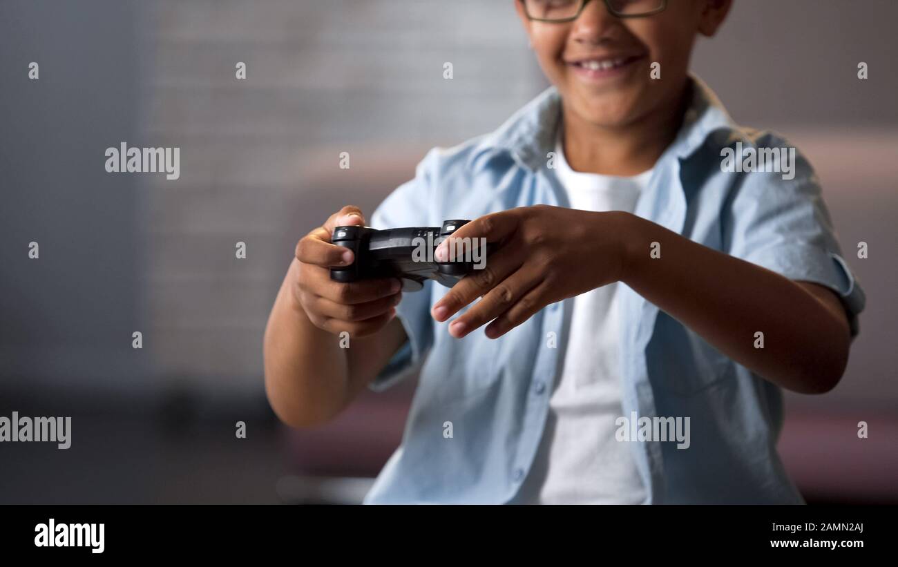 Happy and joyful kid laughing playing new game console for first time ...