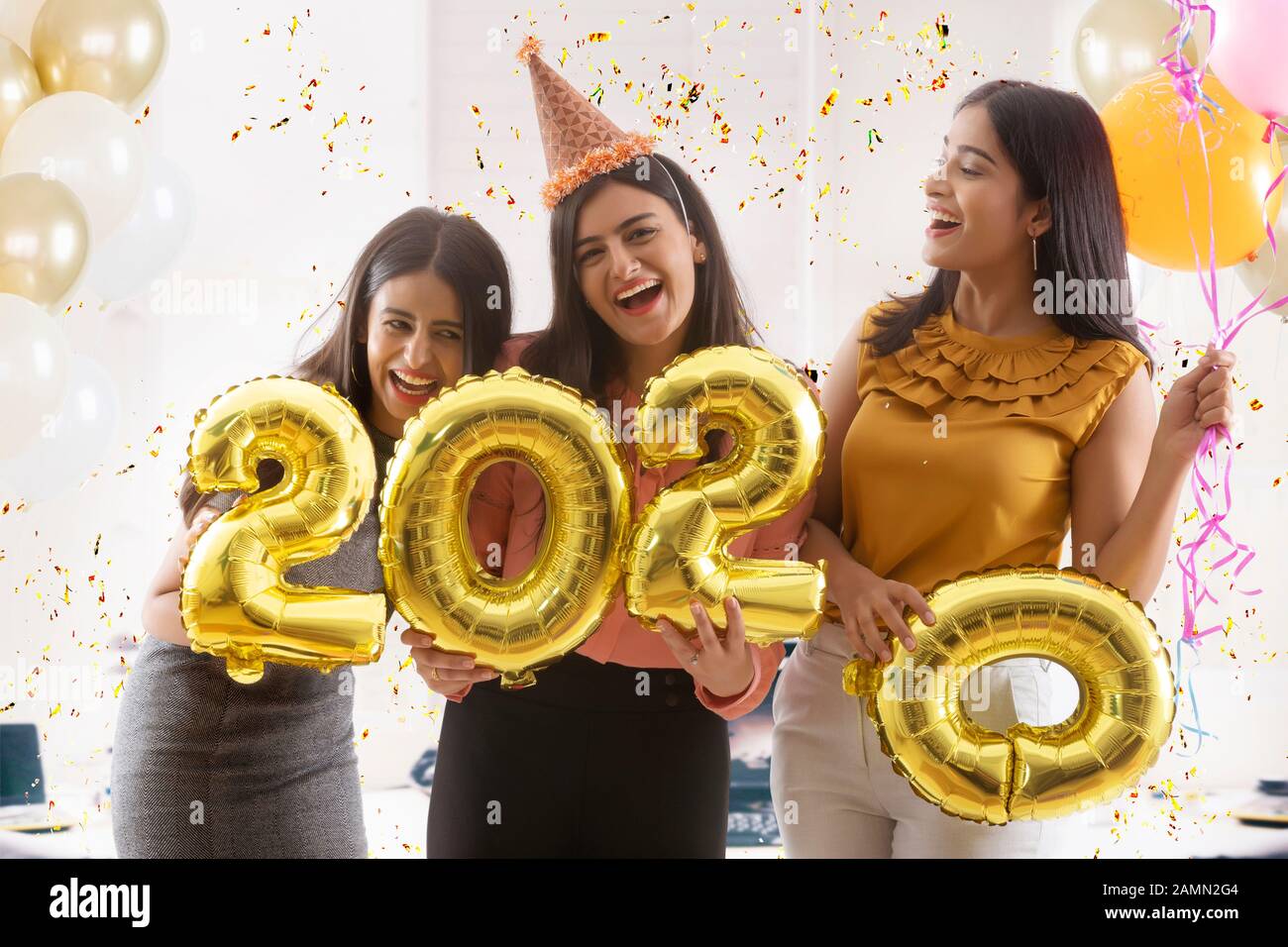 Friends partying together in office holding 2020 balloons Stock Photo ...