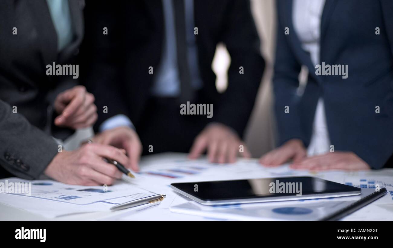 Managers discussing company development plan, considering business ...