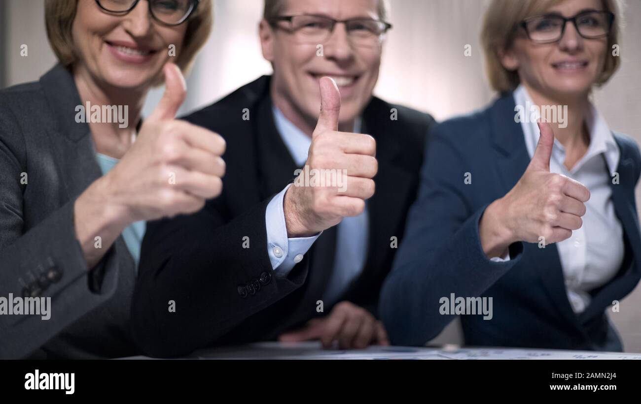 Happy business people with thumbs up, satisfied with successful ...