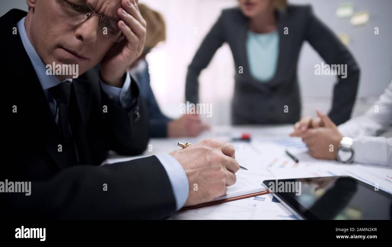 Tired office worker feeling scared, suffering at meeting with terror ...