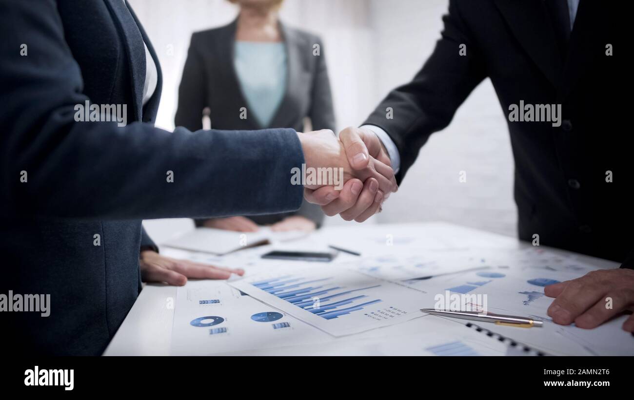 Company representatives handshaking after contract sign, partnership ...
