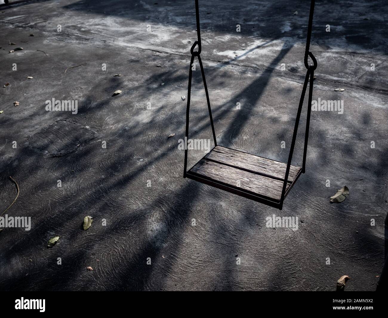 Old lonely wooden swing on sunset time with light and shadow. Vintage ...