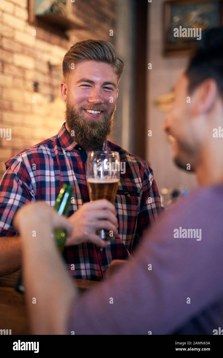 Portrait of smiling man drinking beer in the pub Stock Photo - Alamy