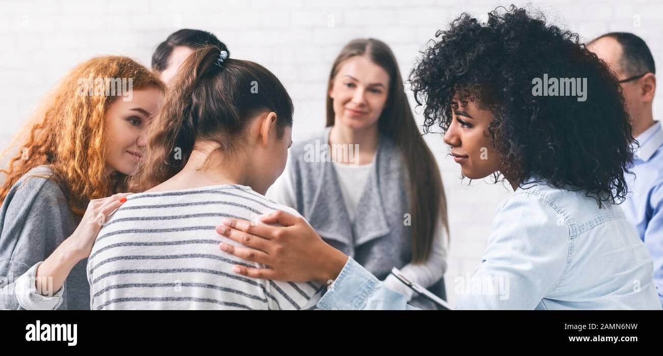 Support group patients comforting woman at therapy session Stock Photo ...