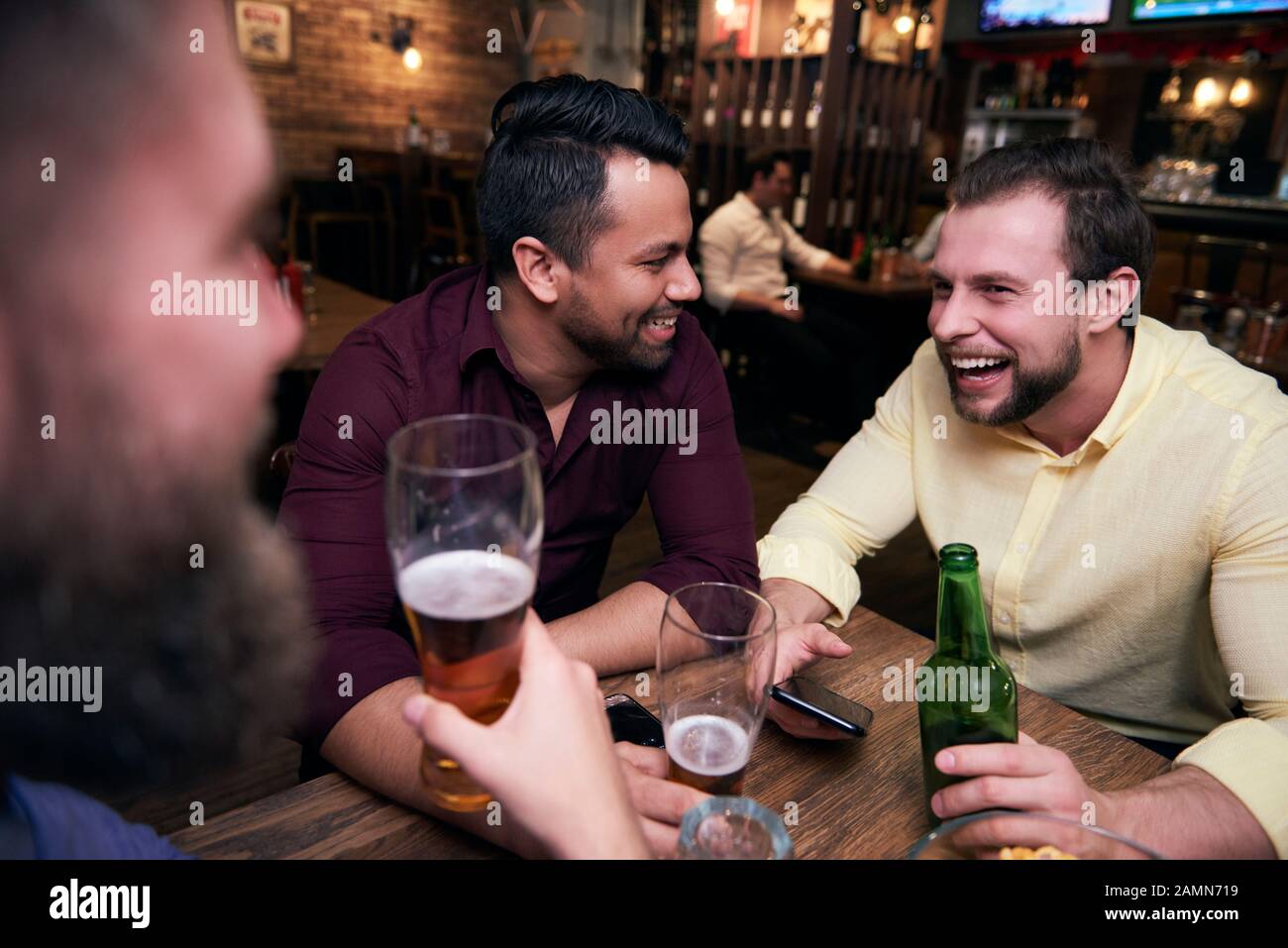 Male friends chilling with drinks at the bar Stock Photo - Alamy