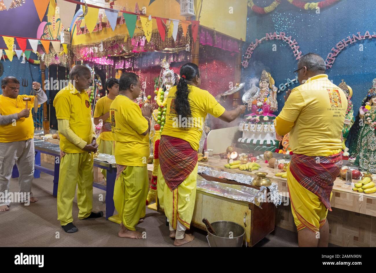 Male Hindu worshippers perform the arti ritual where flames are waved ...