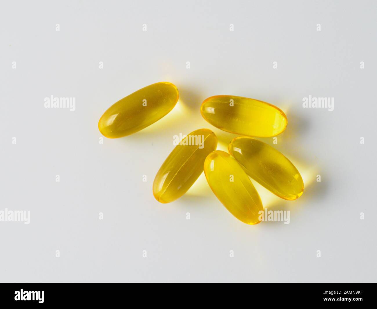 Omega 3 fish oil capsules isolated on white background. Golden color ...