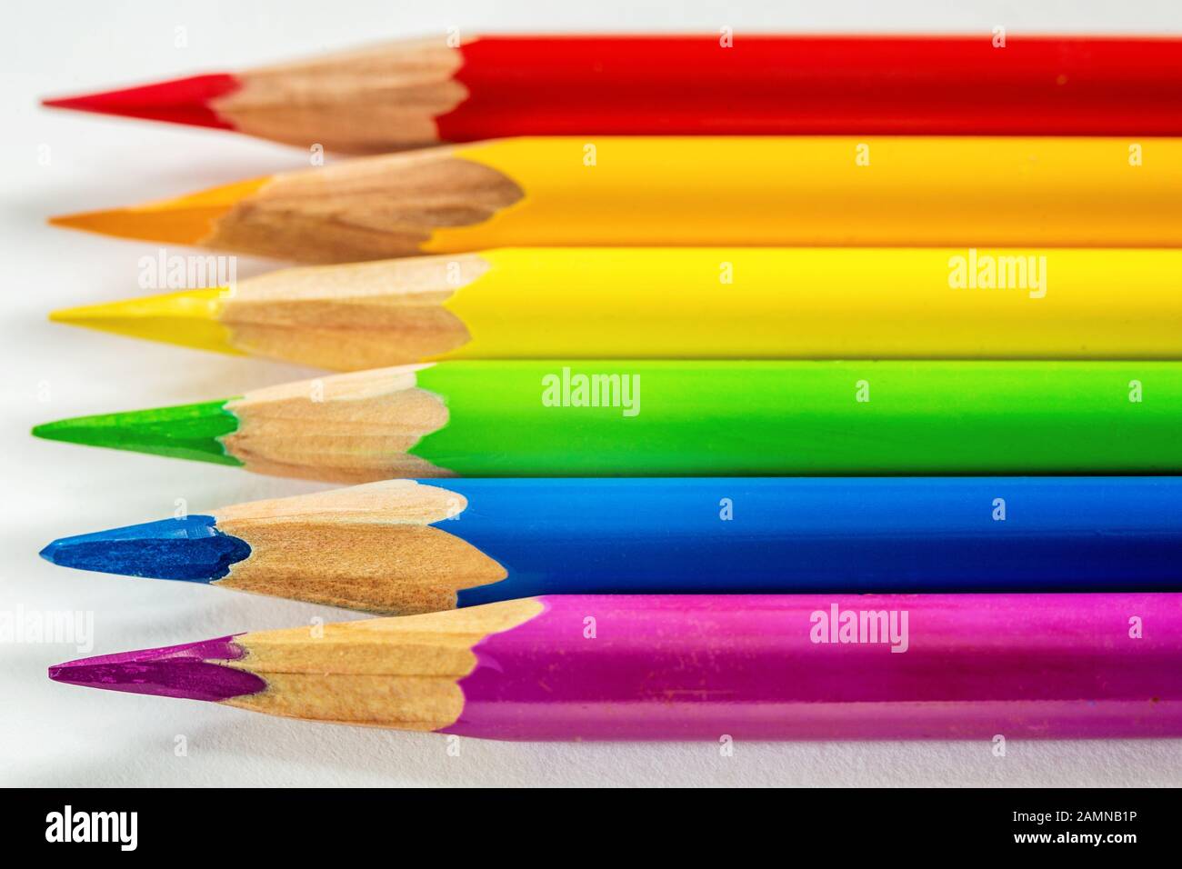 Seven colored pencils creating rainbow white background Stock Photo - Alamy