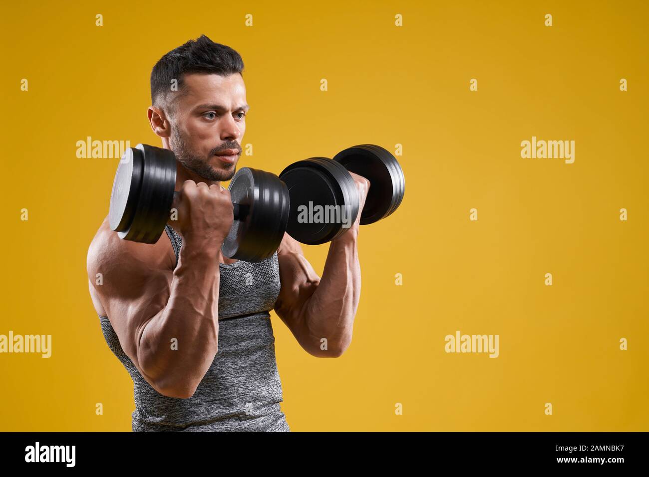 Side view of strong athletic guy doing heavy weight lifting workout ...