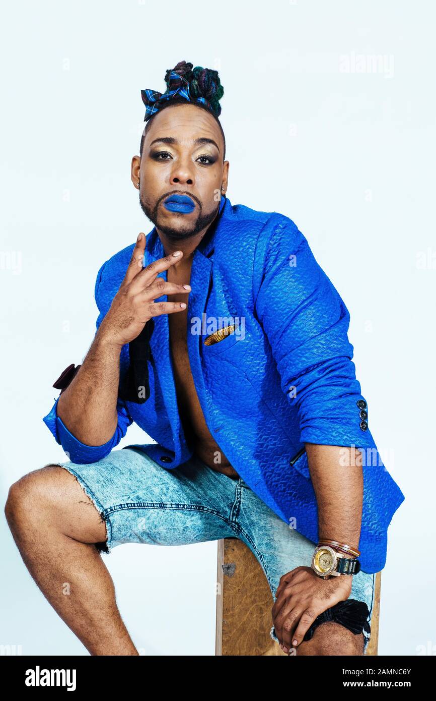 Portrait of a man with blue lips dressing in blue sitting . Studio ...